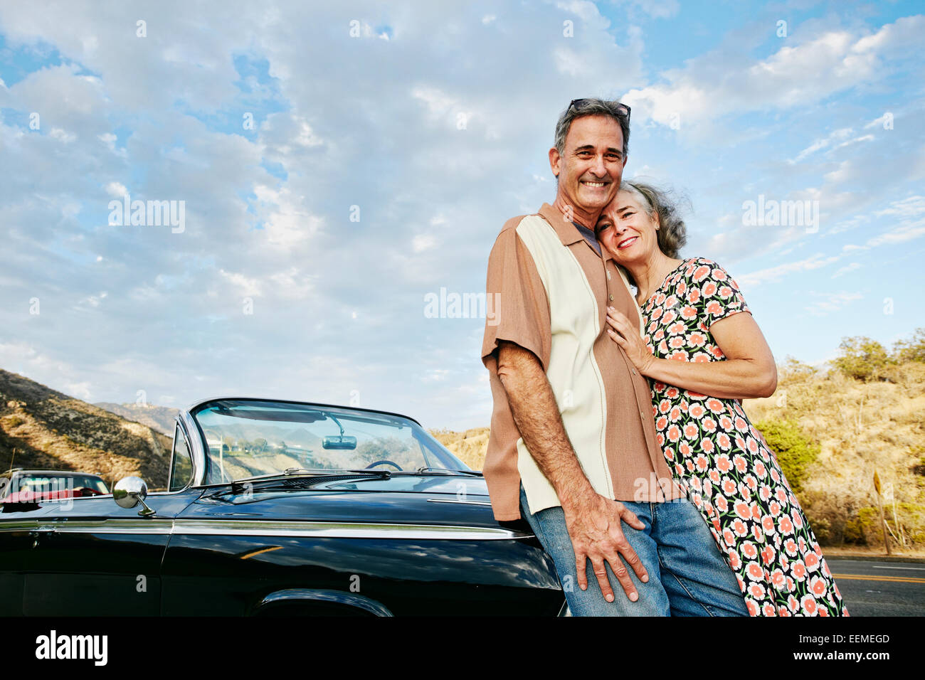 Couple smiling near classic convertible Stock Photo - Alamy