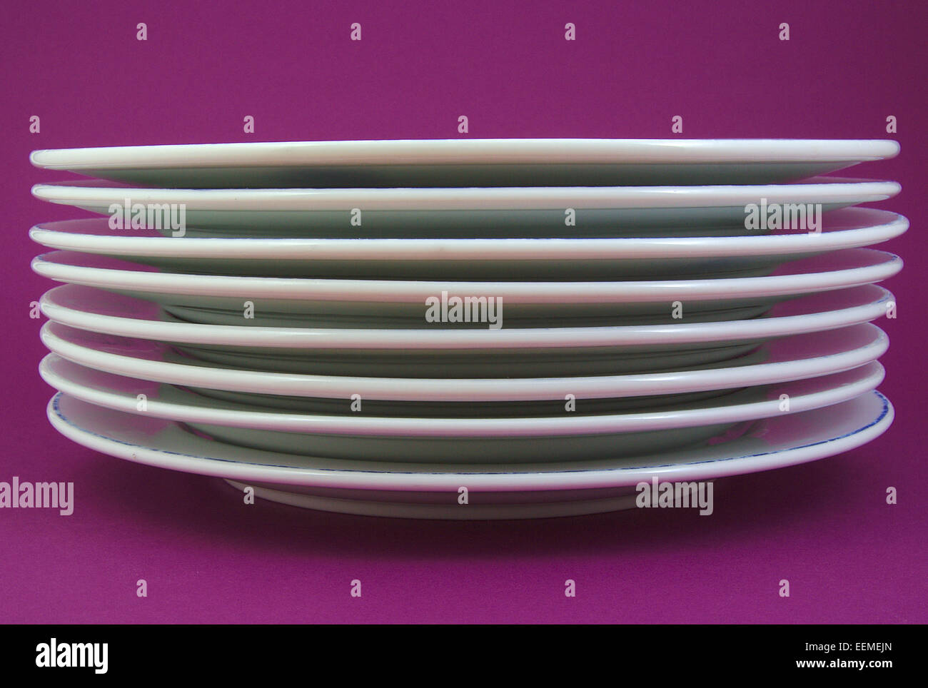 Stack of white and used dishes on purple background Stock Photo - Alamy