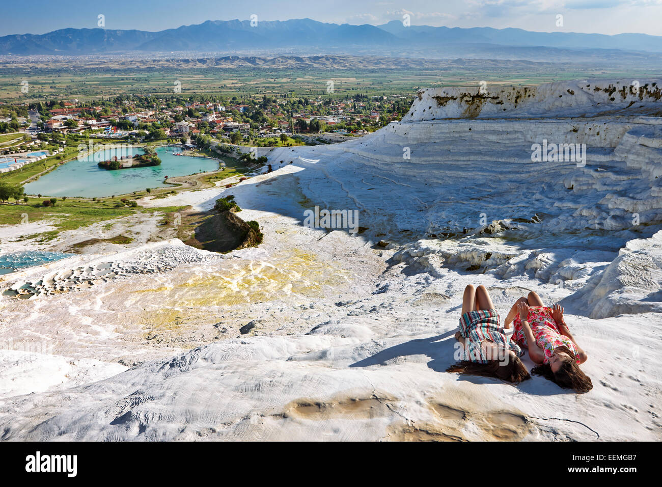 Two girls sunbathing on travertine terraces of Pamukkale. Denizli ...