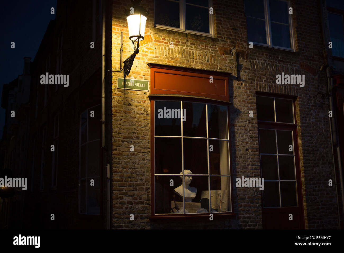 Female bust in a window at night under Rozenhoedkaai street sign ...