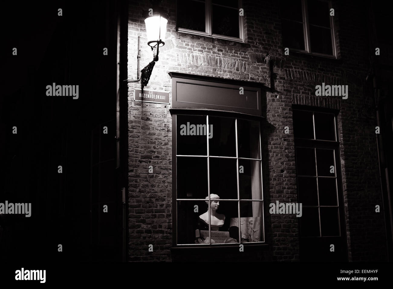 Female bust in a window at night under Rozenhoedkaai street sign ...