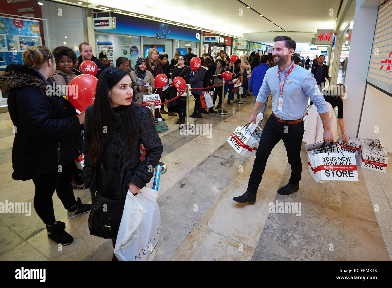 Staff member handing out goodie bags during the opening of a new H&M ...