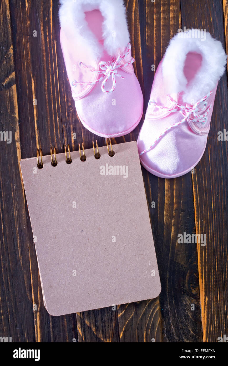 baby shoes and notepad for note on a table Stock Photo - Alamy