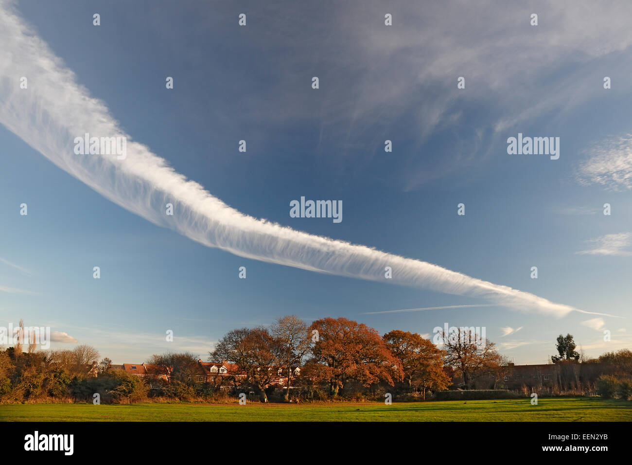 Aircraft vapour trail in late afternoon light over Willaston Village ...