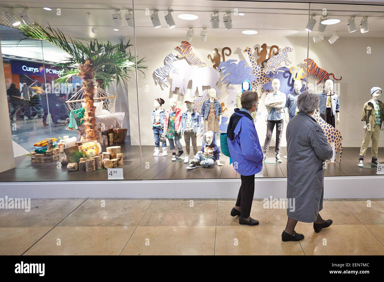 Shoppers walk past a shop window display Stock Photo - Alamy