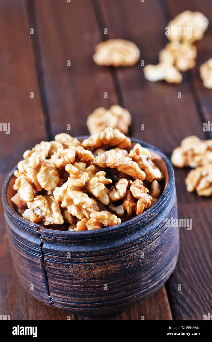 walnuts in wooden bowl and on a table Stock Photo - Alamy