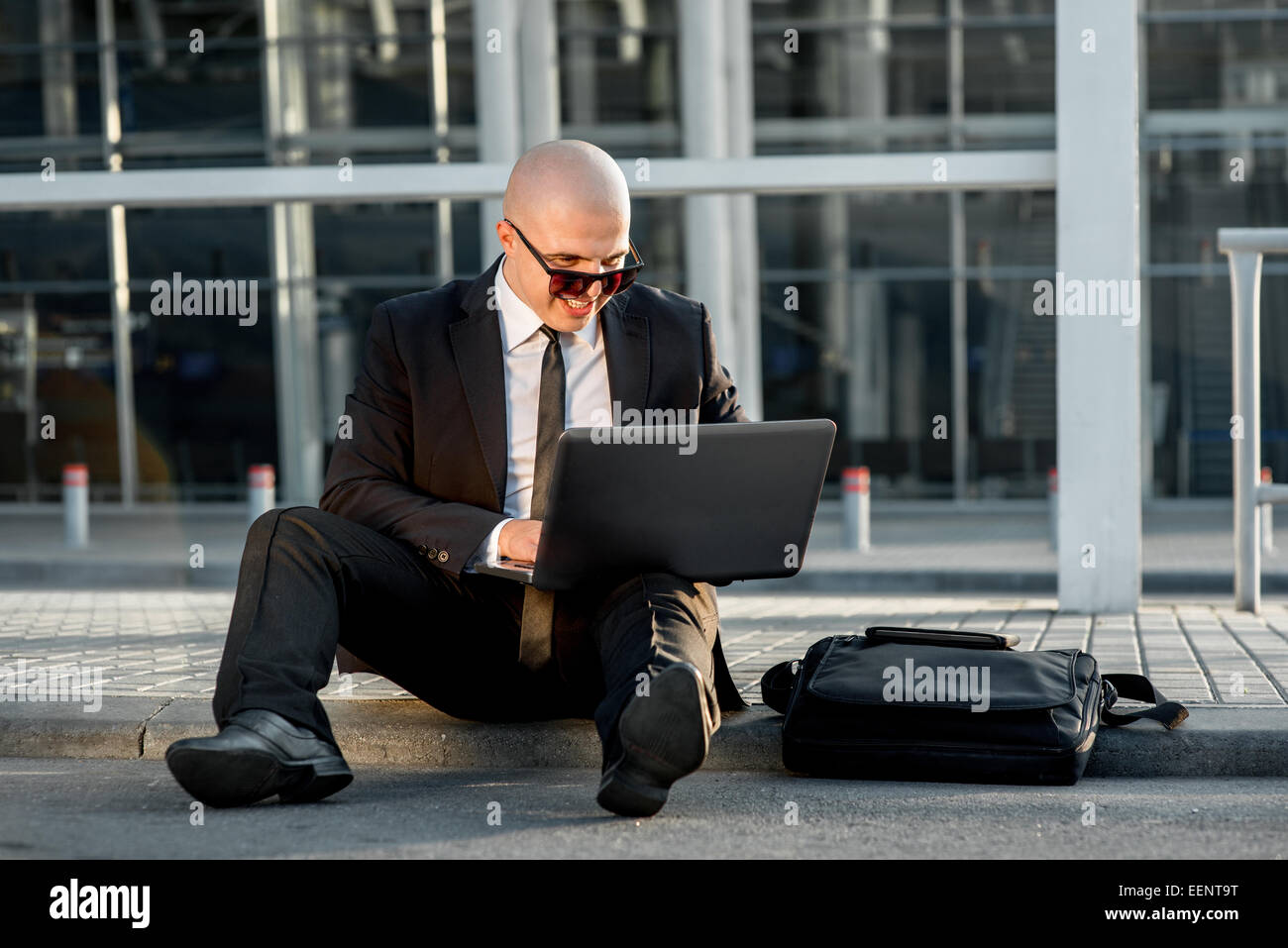 Businessman or banker working with laptop outside the airport or ...