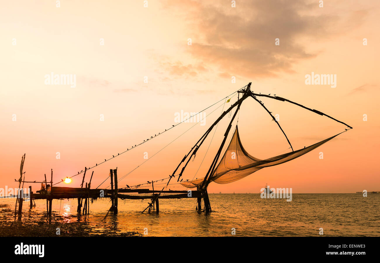 A Chinese fishing net at rest as the sun sets over the Arabian Sea at ...