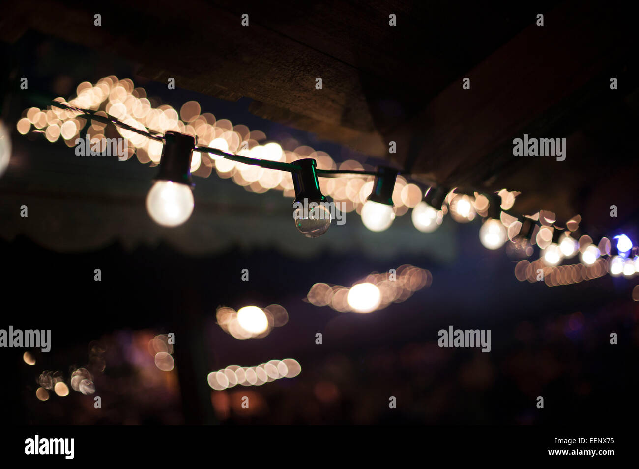 A broken light in a long line a glowing bulbs Stock Photo - Alamy