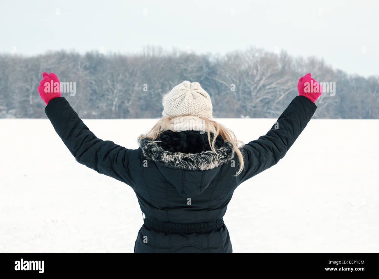 winter woman in snow showing her back and facing forest with fist hands ...