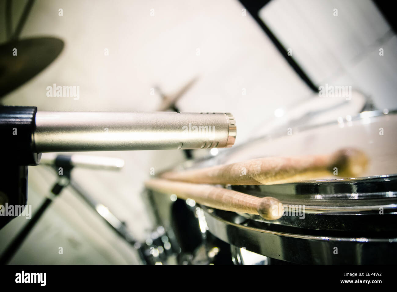 vintage retro professional microphone placed close to drums with sticks ...