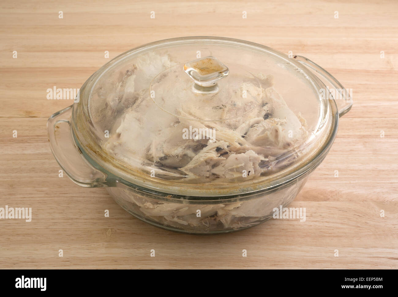 An old covered glass bowl filled with a large portion of turkey on a ...