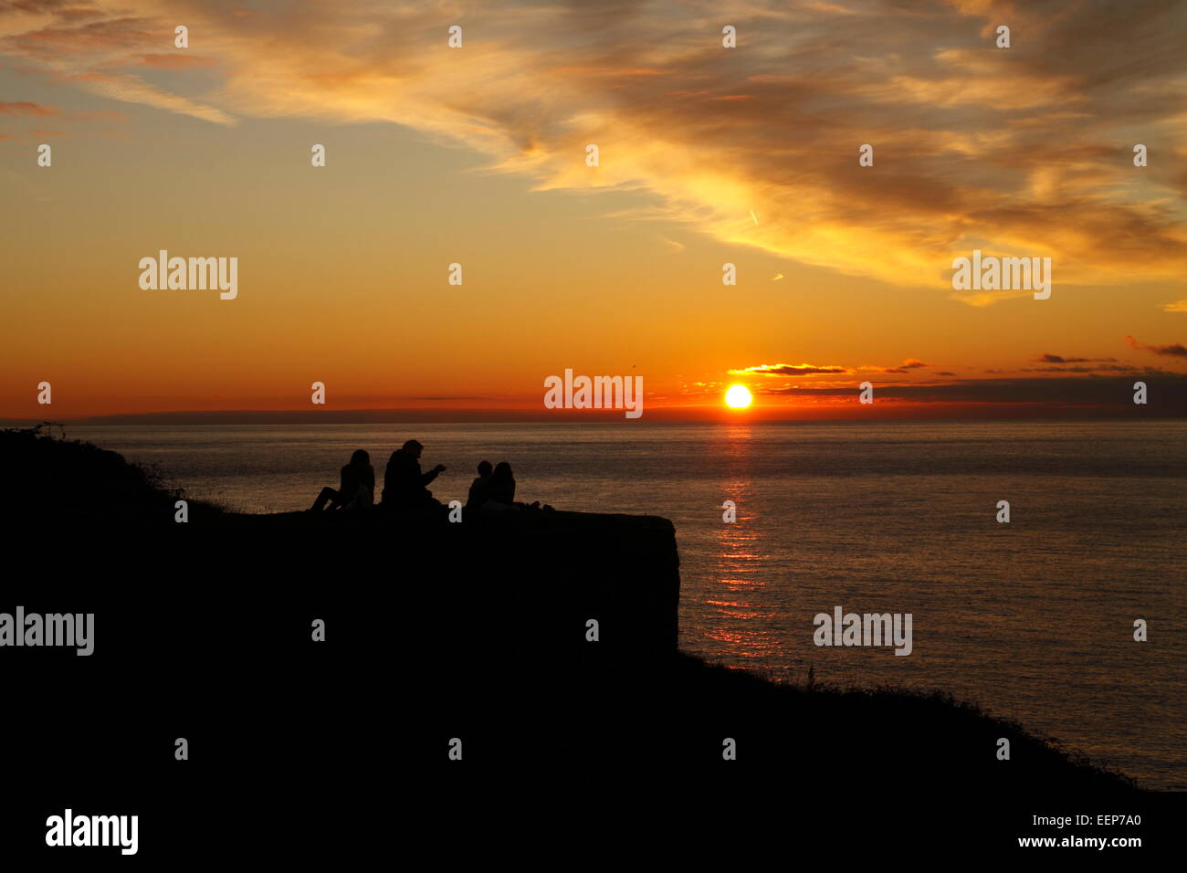 People enjoying the sunset at Mwnt Beach on an old lime kiln Stock ...
