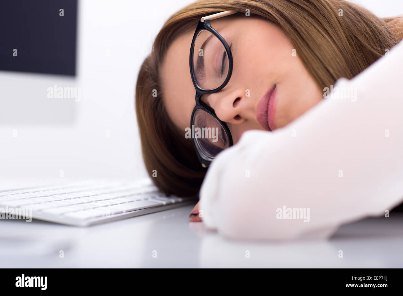 Tired businesswoman in glasses sleeping at her workplace in office ...