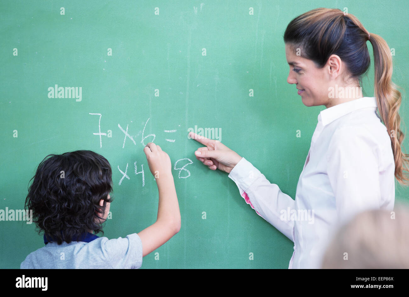 Teacher questioning kid at chalkboard Stock Photo - Alamy