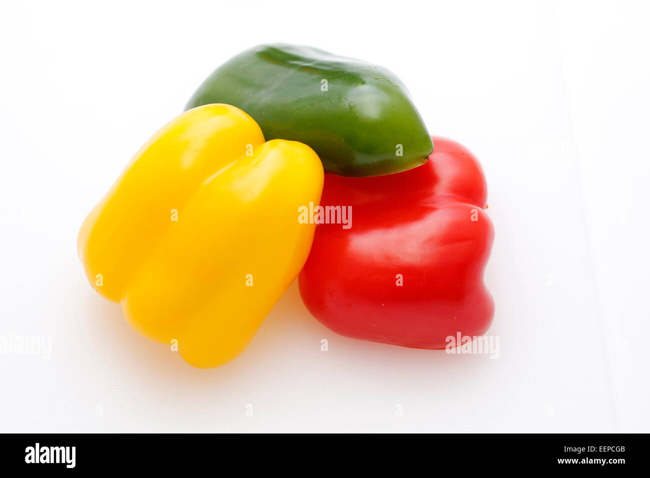 three colored peppers green red yellow in white background Stock Photo ...