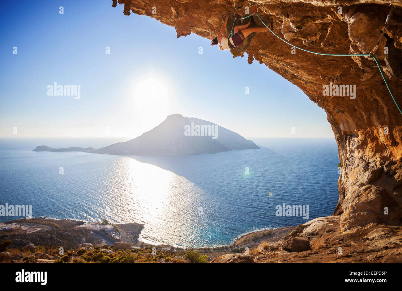 Female rock climber climbing along roof in cave Stock Photo - Alamy