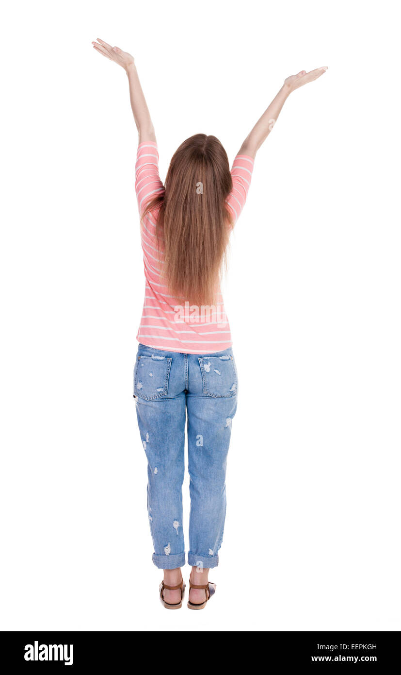 Back view of Beautiful woman in jeans looking at wall and Holds hand up ...