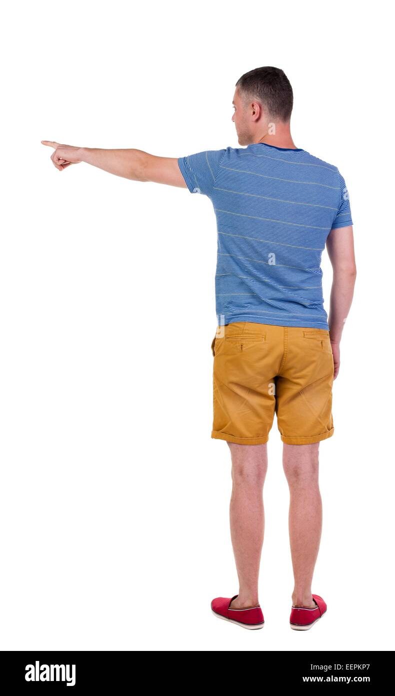 Back view of pointing young men in shorts. Young guy gesture. Rear view ...