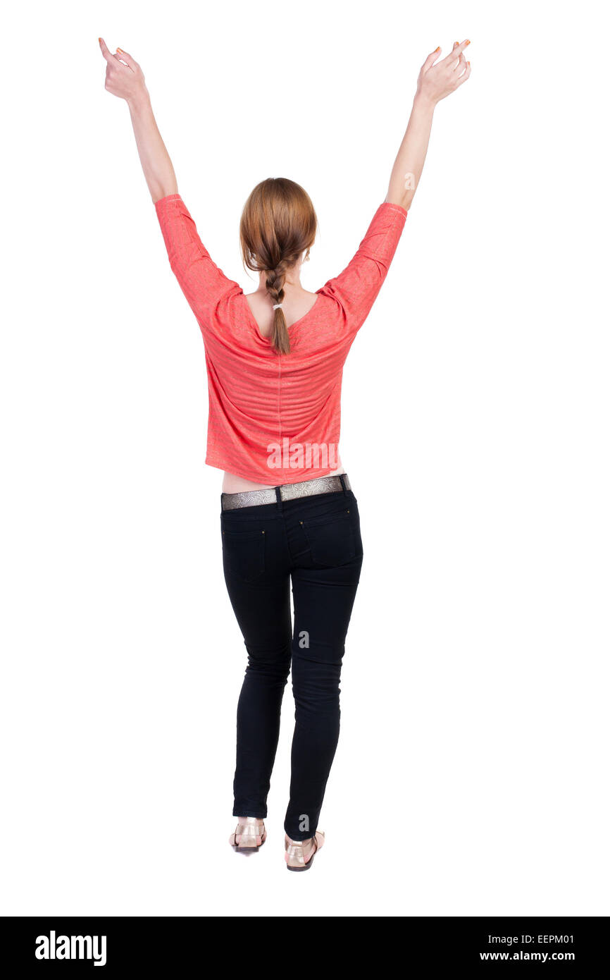 Back view of Beautiful woman in jeans looking at wall and Holds hand up ...
