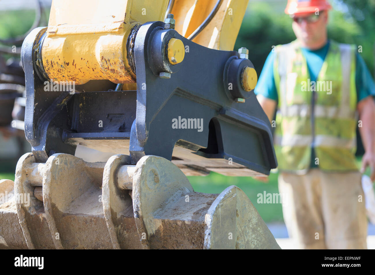 Construction worker watching excavator bucket Stock Photo - Alamy