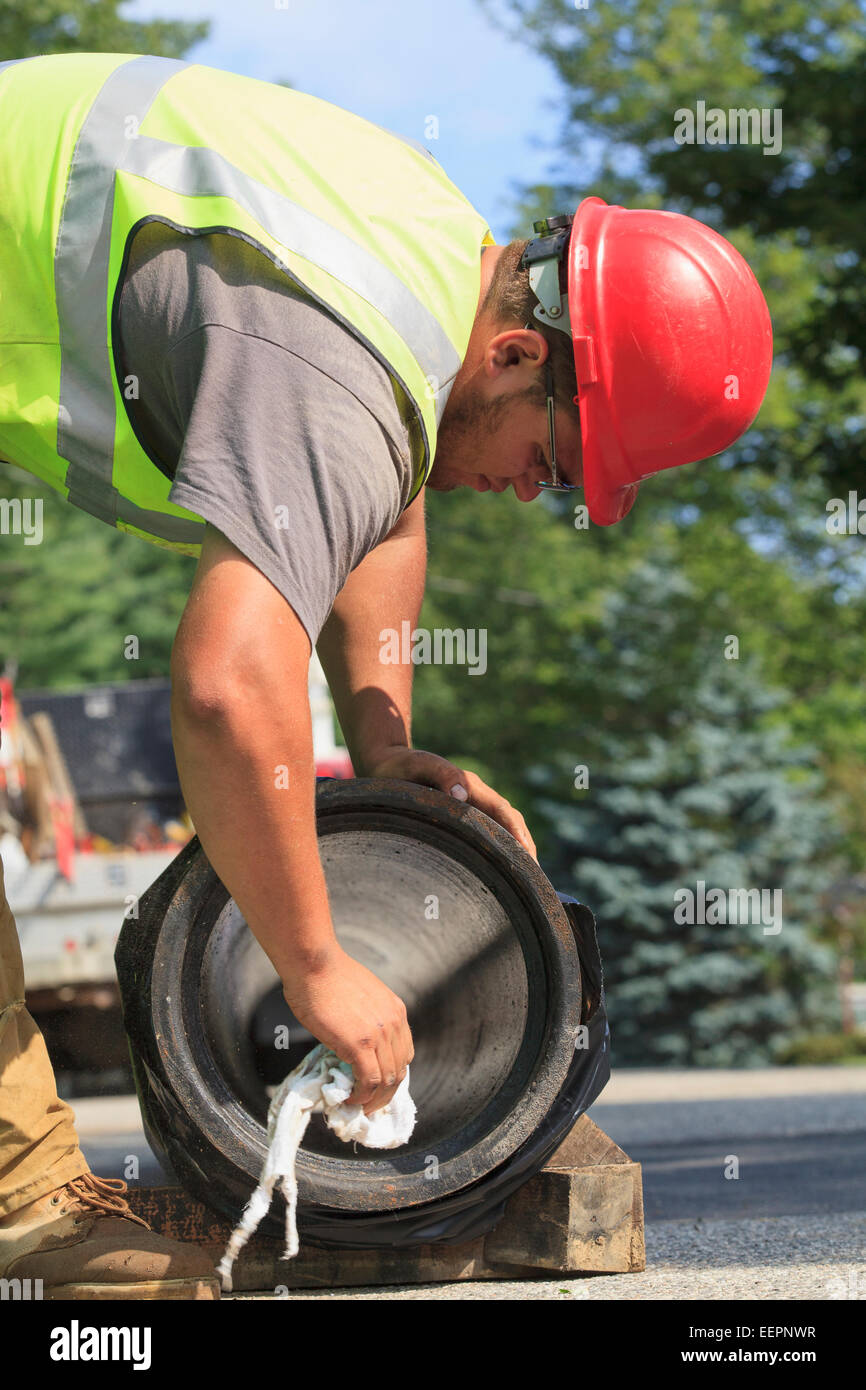 Construction worker preparing water main for installation Stock Photo ...