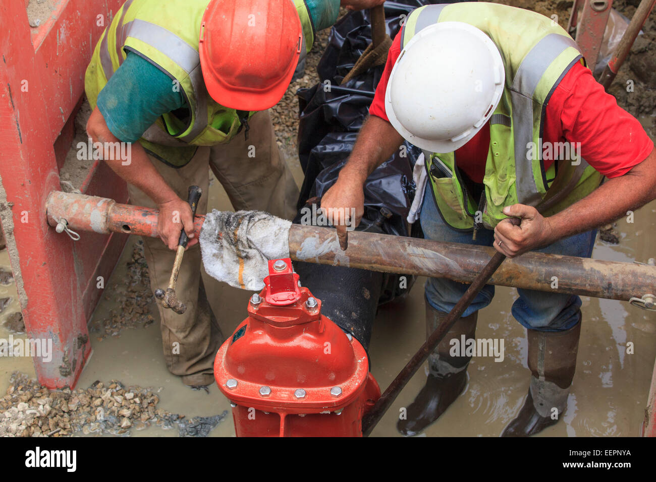 Construction workers adjusting gate valve position on water main Stock ...