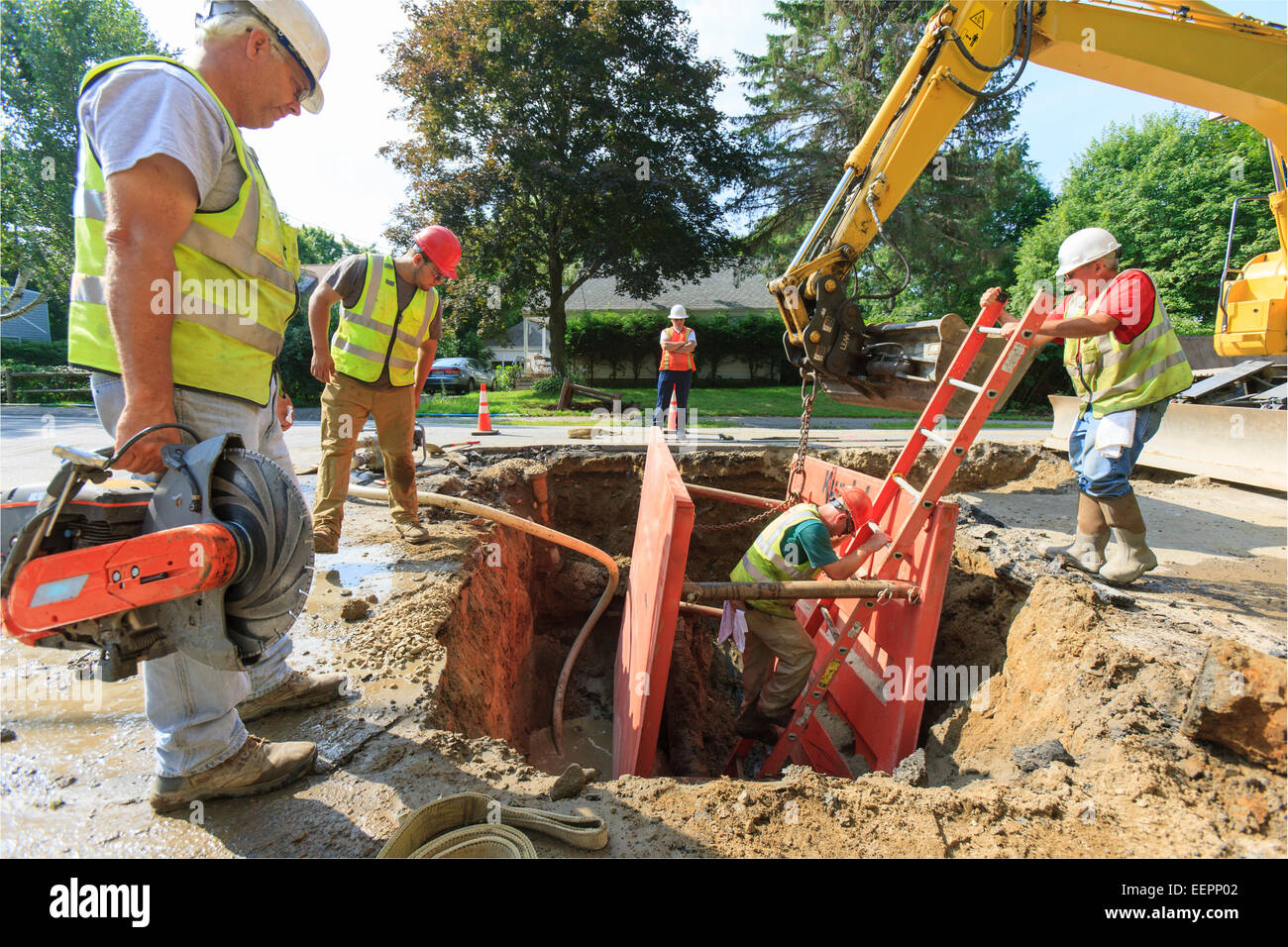 Construction worker placing shoring into hole with excavator Stock ...
