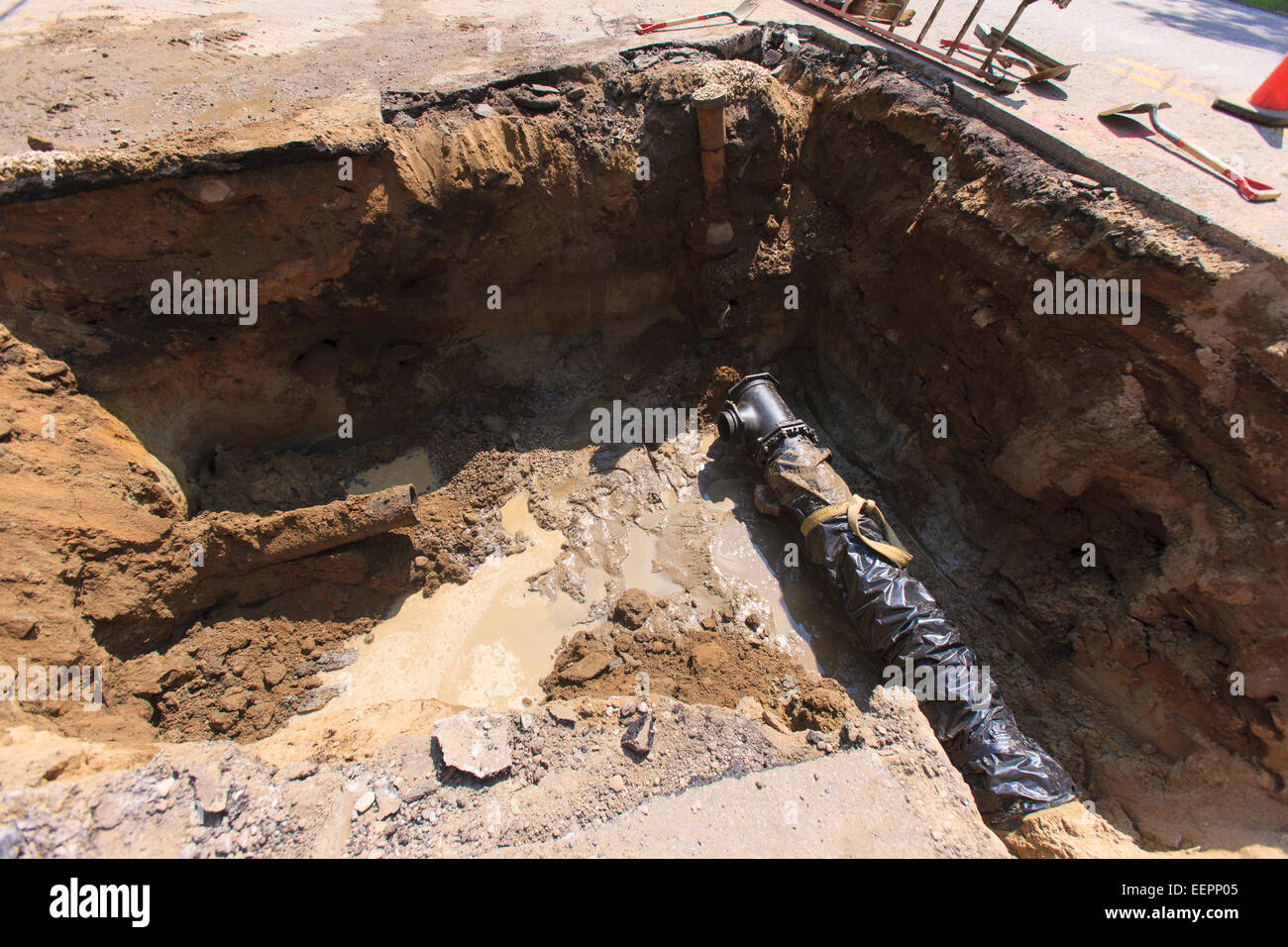Section of new water main and old piping in street hole Stock Photo - Alamy