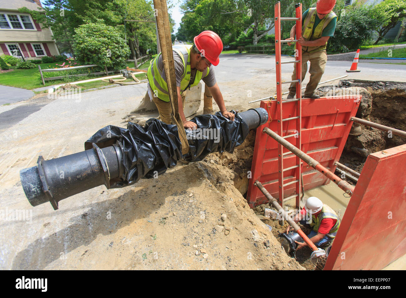 Construction worker preparing to lower water main section Stock Photo ...