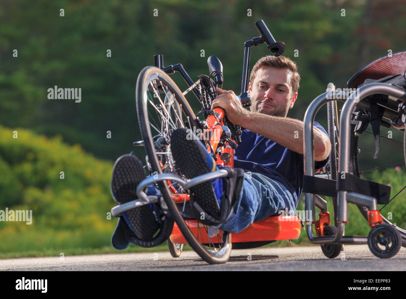 Man with spinal cord injury adjusting his feet on his custom adaptive ...