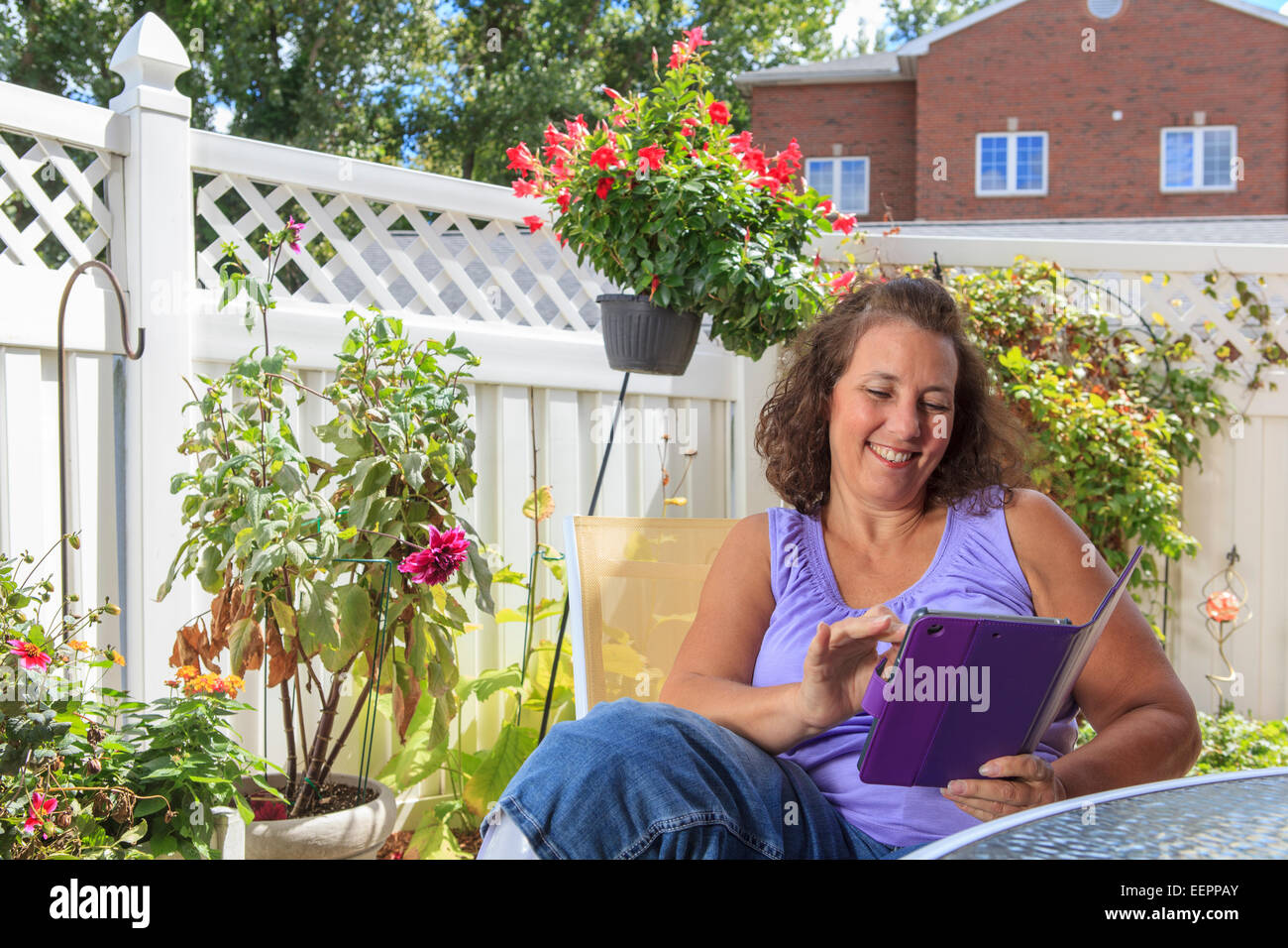 Woman with Spina Bifida on patio working on tablet Stock Photo - Alamy