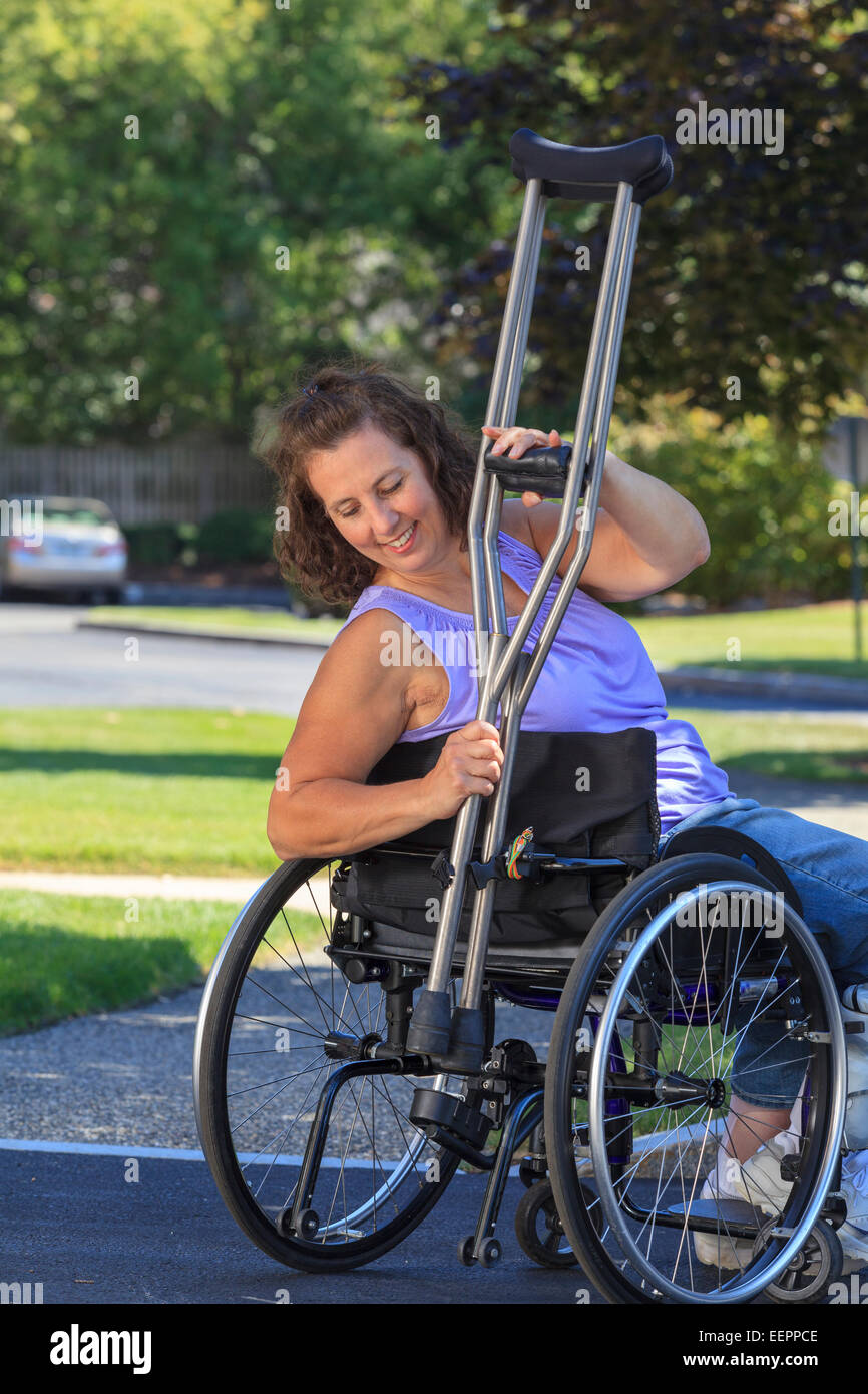 Woman with Spina Bifida attaching crutches to wheelchair Stock Photo ...