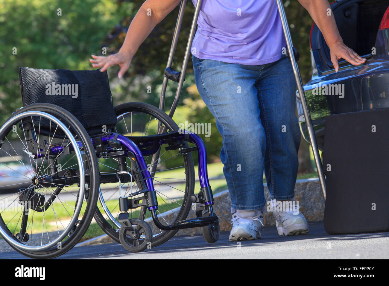 Woman with Spina Bifida about to sit in wheelchair after putting it ...