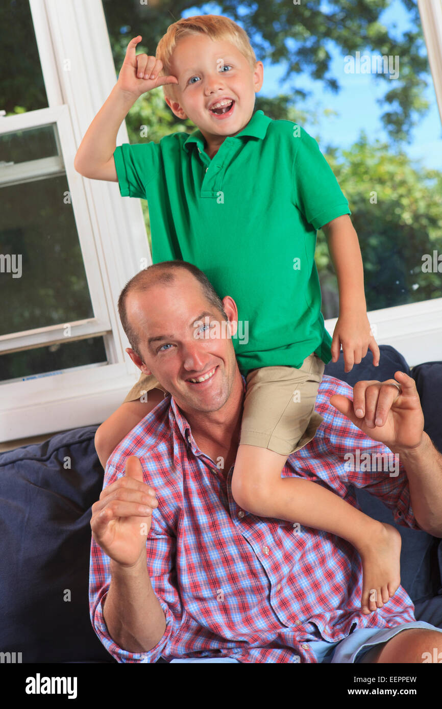Father and son with hearing impairments signing 'cowboy, play' in ...
