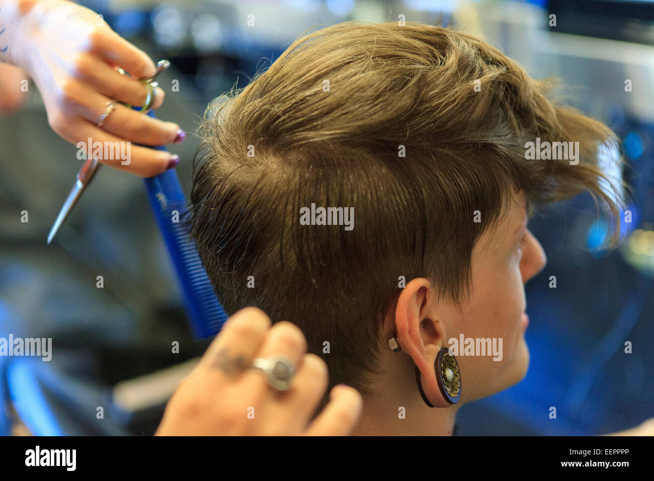 Stylish man with a spinal cord injury at a hair salon getting a hair ...