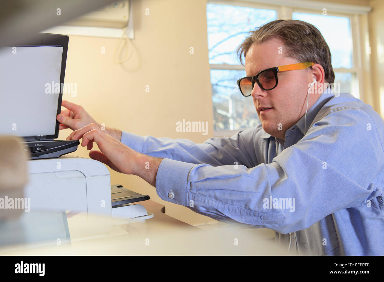 Man with congenital blindness scanning paperwork at his computer Stock ...