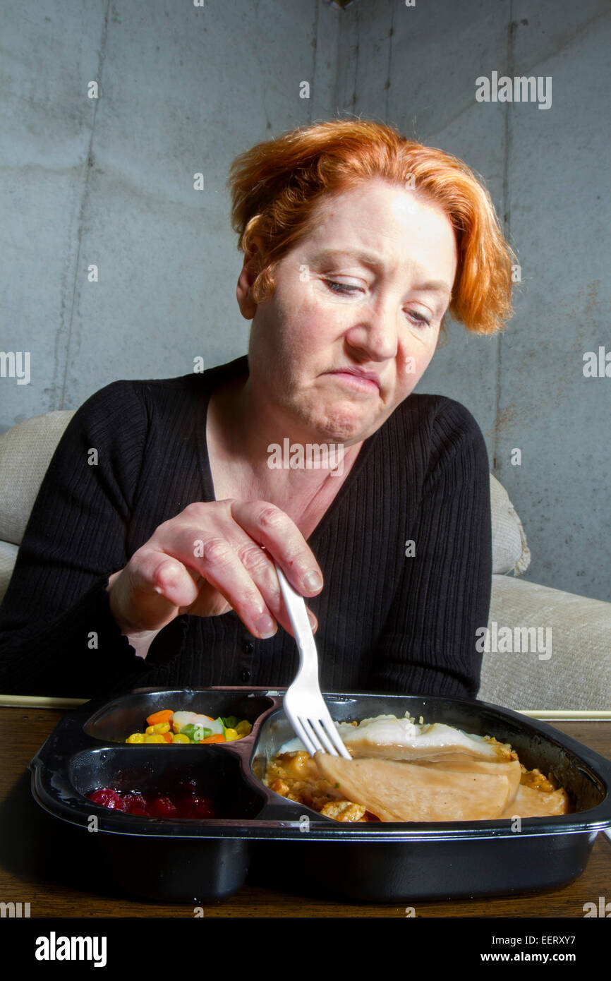 Unhappy woman eating a TV dinner Stock Photo - Alamy