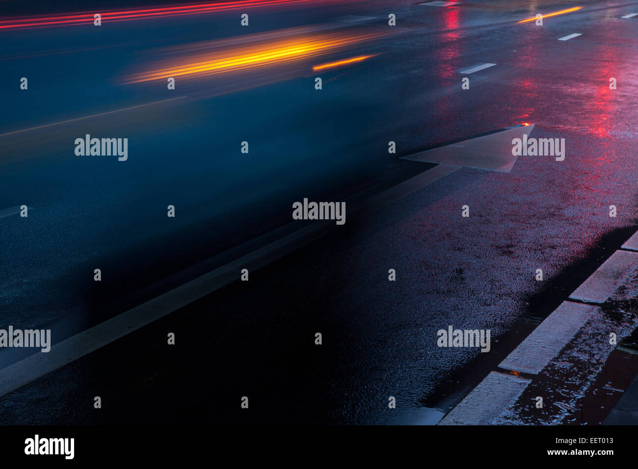 wet road with reflections of traffic lights and speeding cars Stock ...