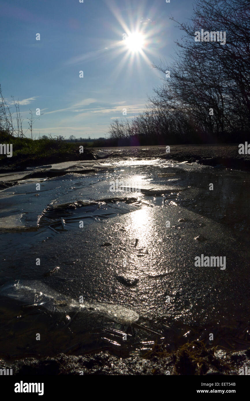 Ice puddle on country lane Stock Photo - Alamy