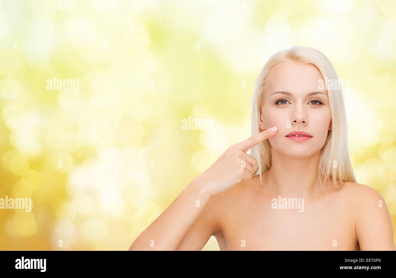 calm young woman pointing at her cheek Stock Photo - Alamy
