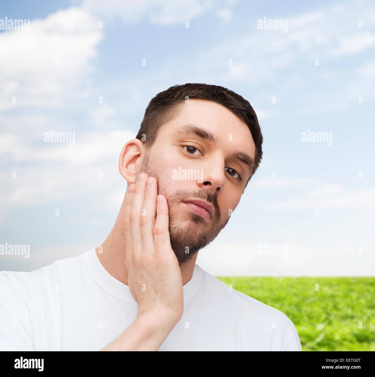 beautiful calm man touching his face Stock Photo - Alamy