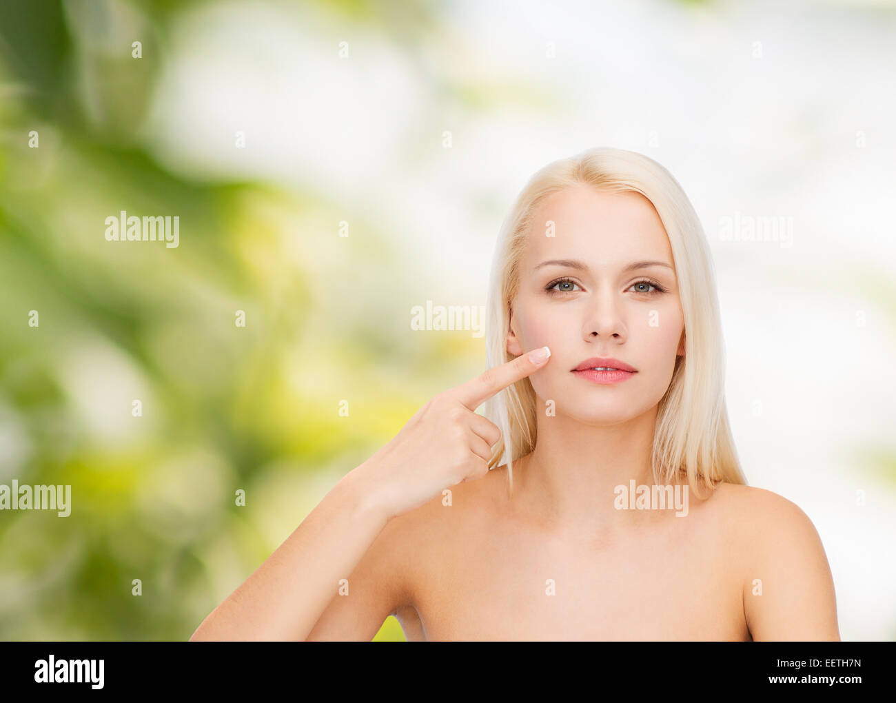 Beautiful woman pointing cheek hi-res stock photography and images - Alamy