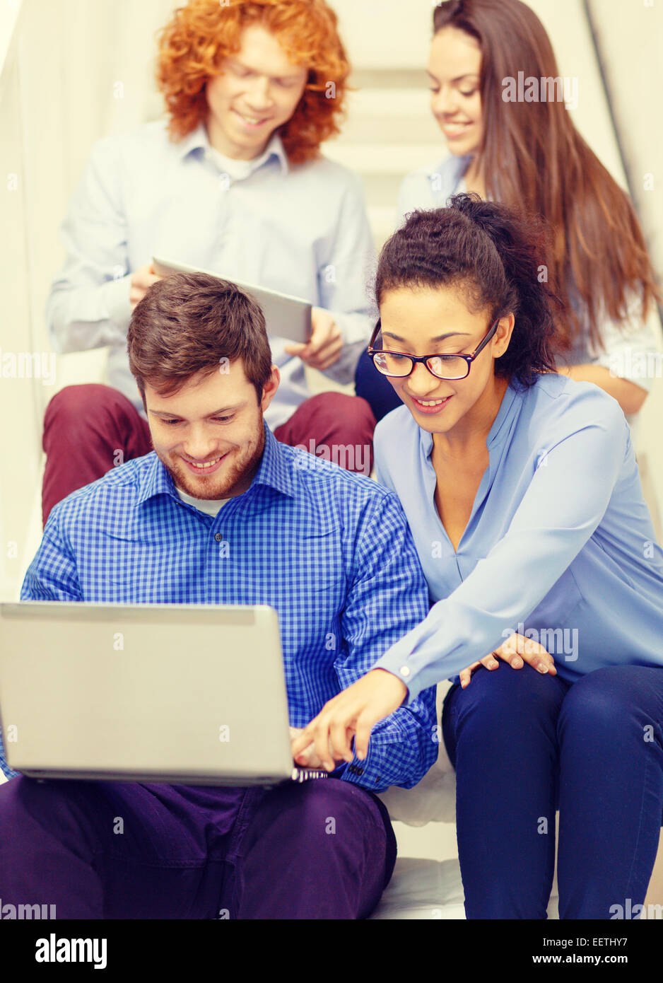 team with laptop and tablet pc on staircase Stock Photo - Alamy