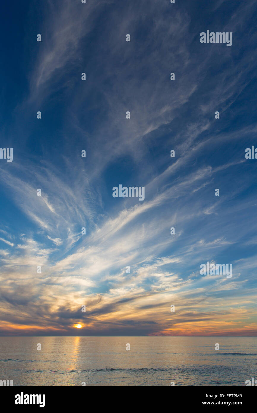 Fine white wispy clouds in sky at sunset over Gulf of Mexico at ...