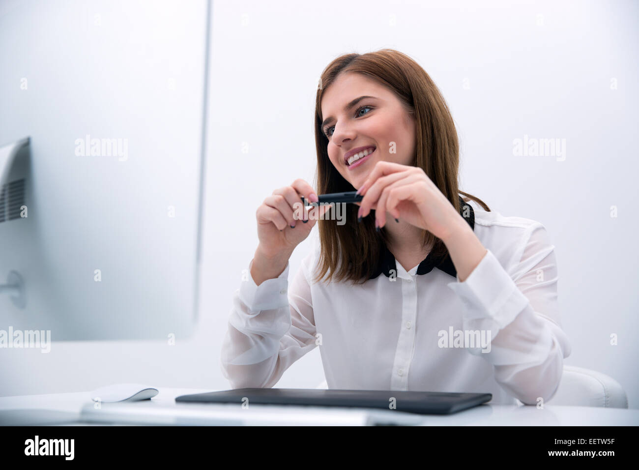 Happy beautiful photo editor working on computer in office Stock Photo ...
