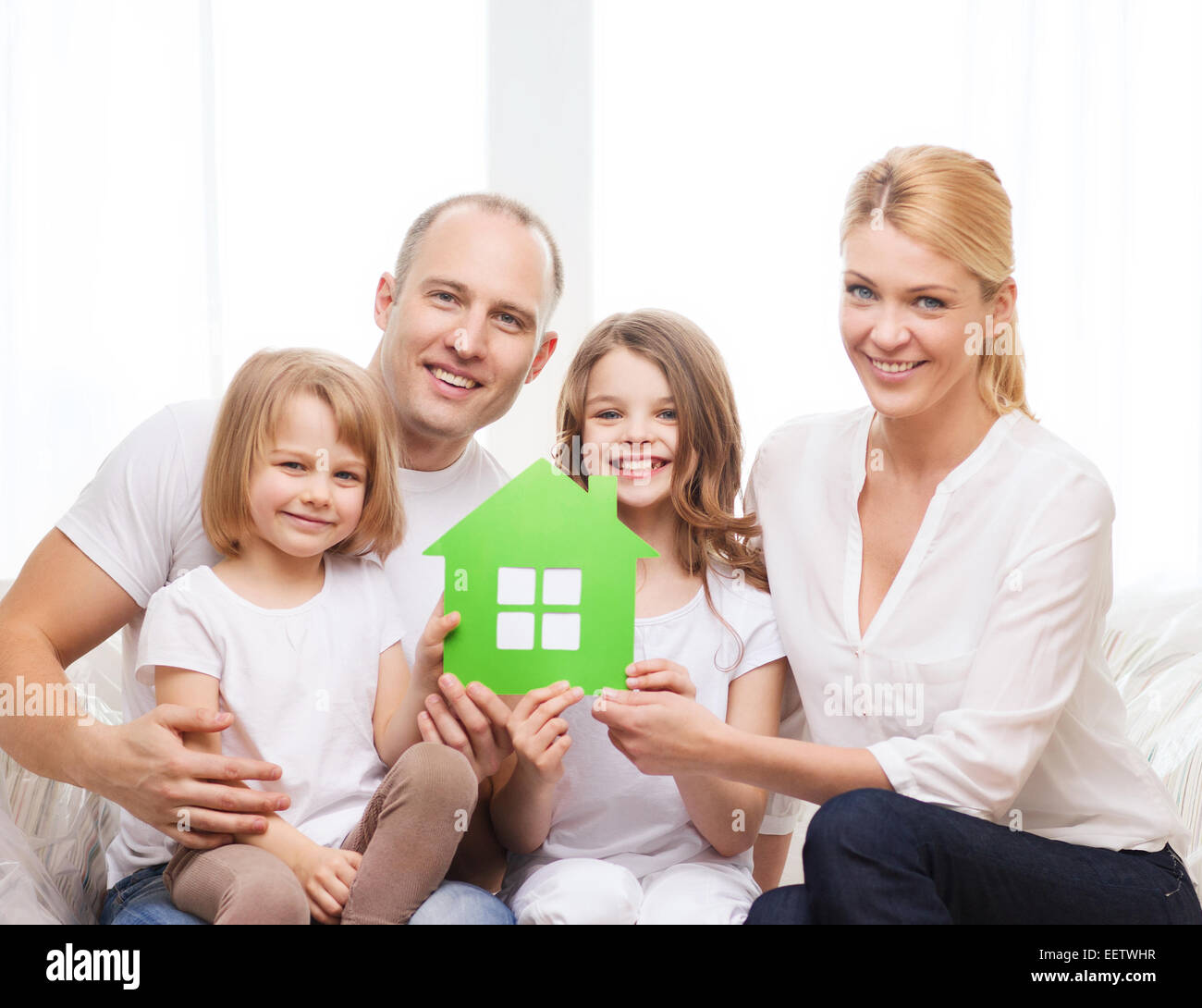 smiling parents and two little girls at new home Stock Photo - Alamy