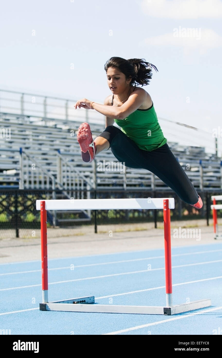 Woman jumping hurdles Stock Photo - Alamy