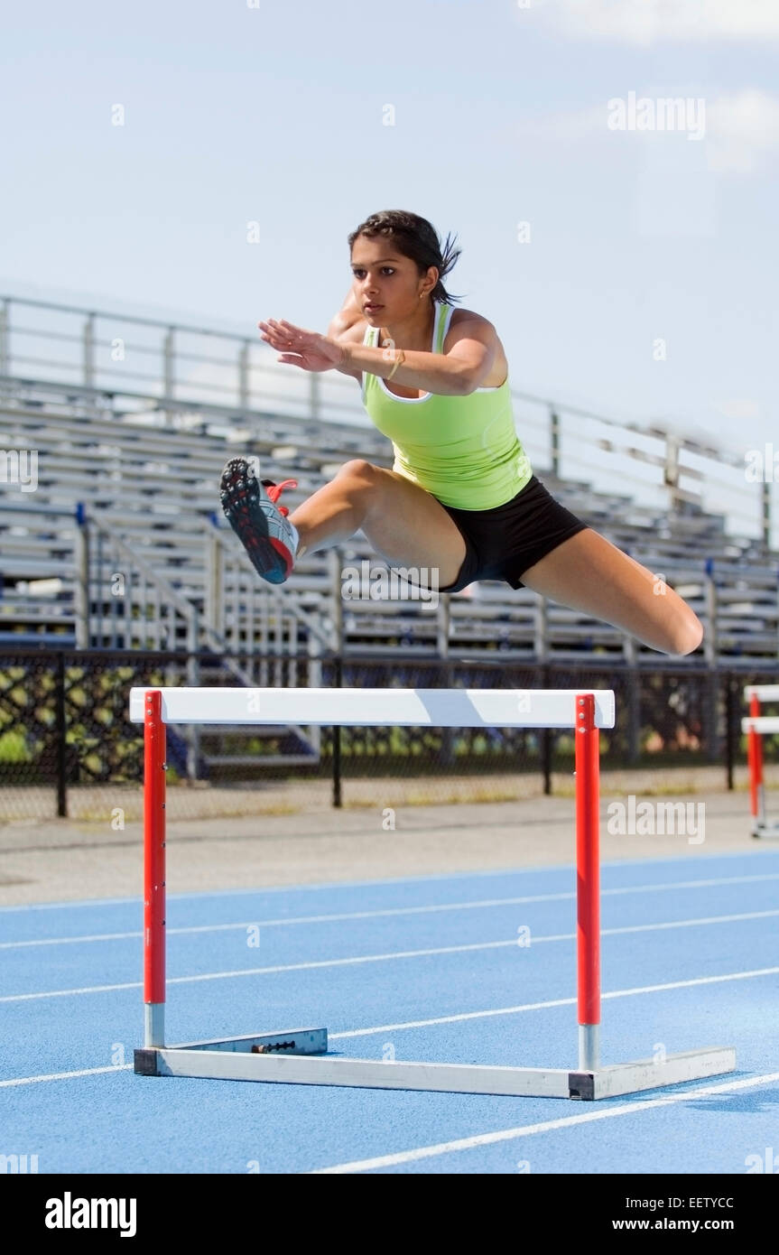 Woman jumping hurdles Stock Photo - Alamy