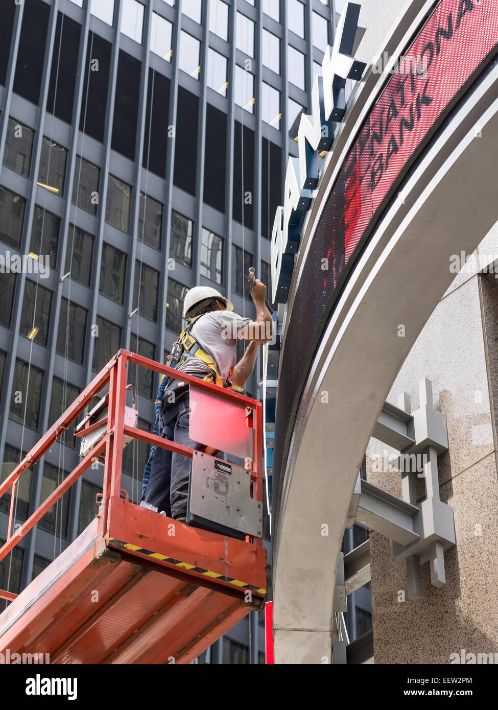 Bank Repair . A worker wields a hammer as he works on the repair or ...